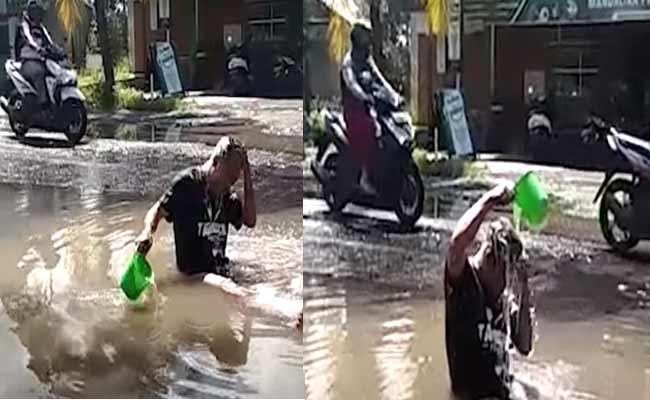 Viral Video: Indonesian Man Bathing And Fishing In Giant Pothole ...